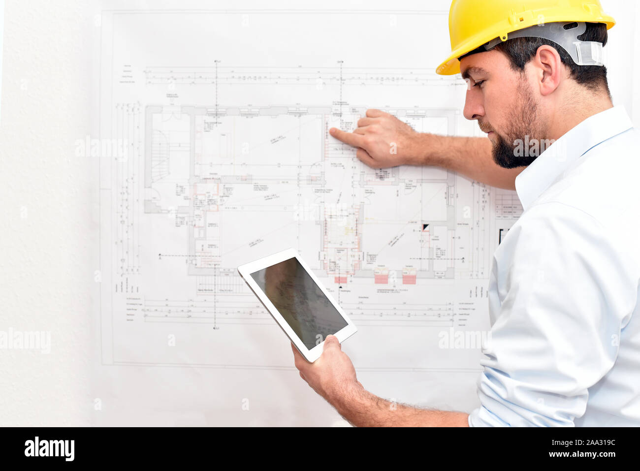 Architect / engineer at his desk planning the construction of a house ...
