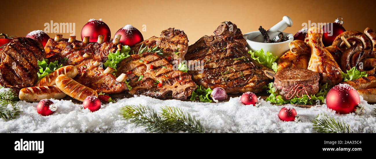 Variety of grilled meat in winter holiday banner concept with snow ...