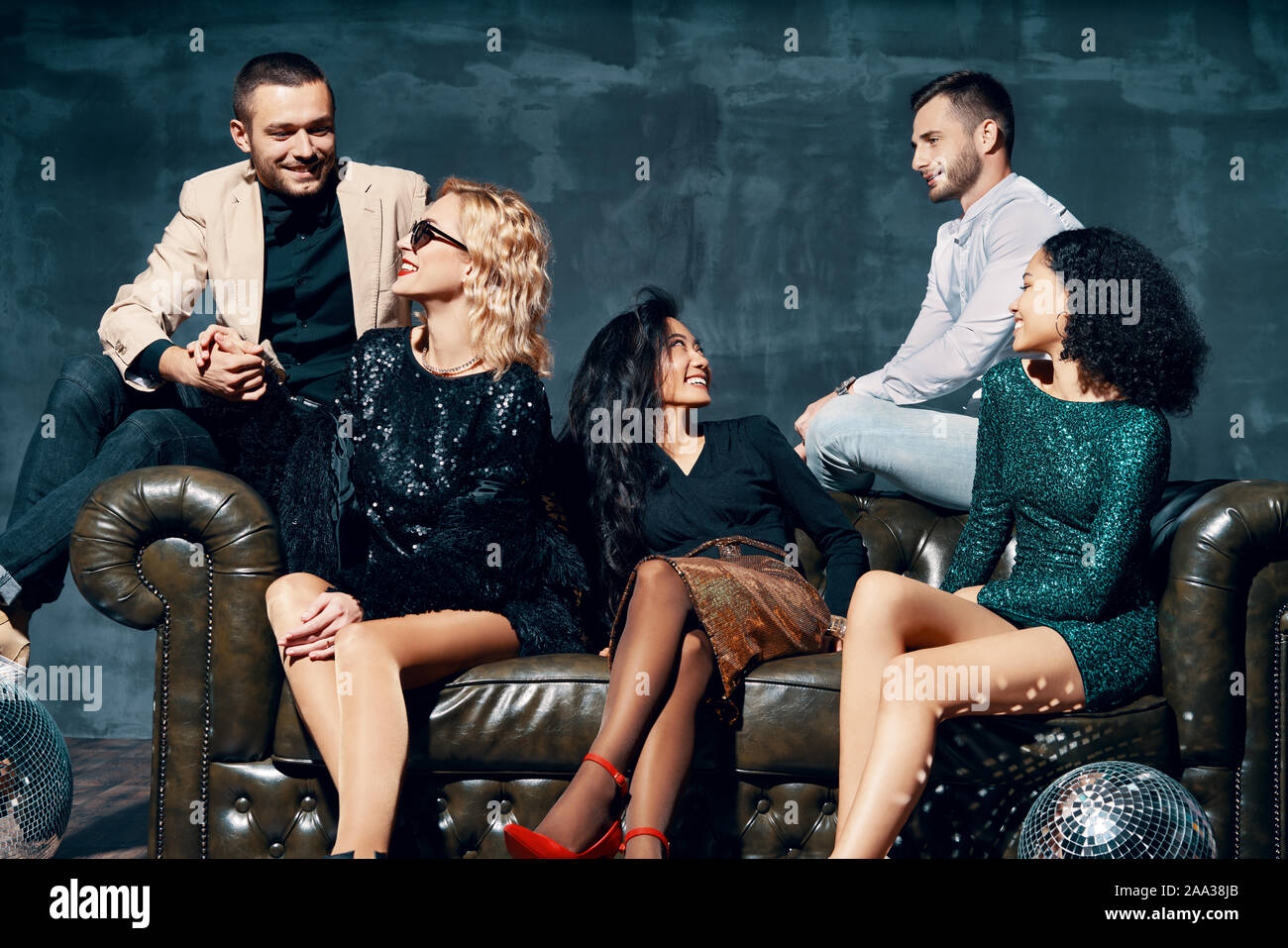 Diverse group of people enjoy party and have fun. Young friends talking ...