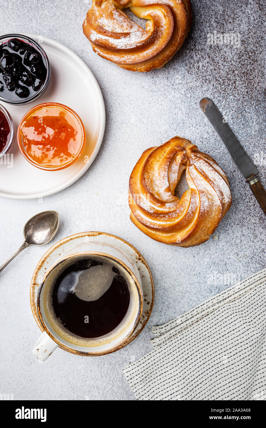 Fresh and bright continental breakfast table with buns with cottage cheese, coffee and jam, top ...