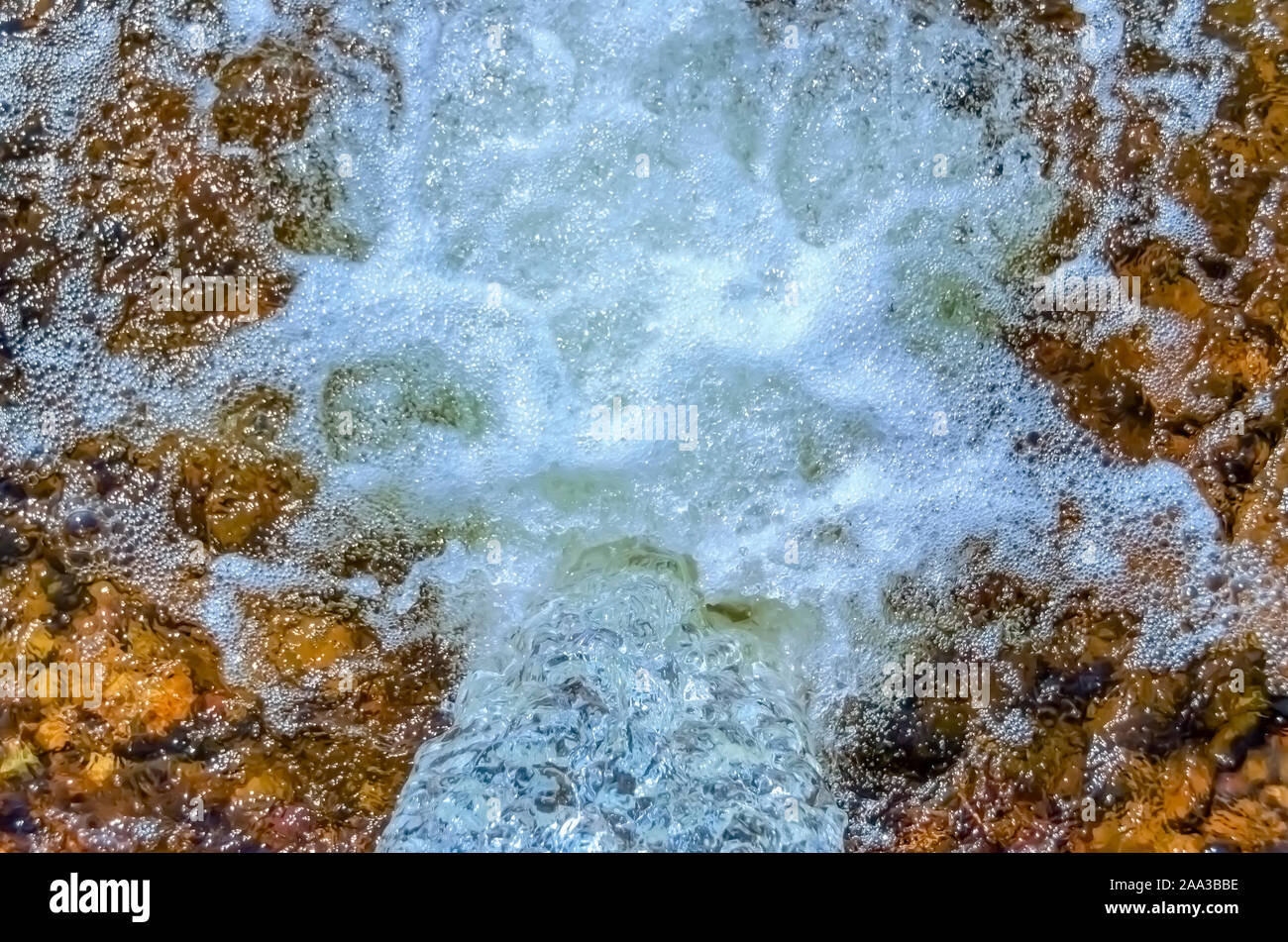 Froth and air bubbles being created as water flows out of a storm ...