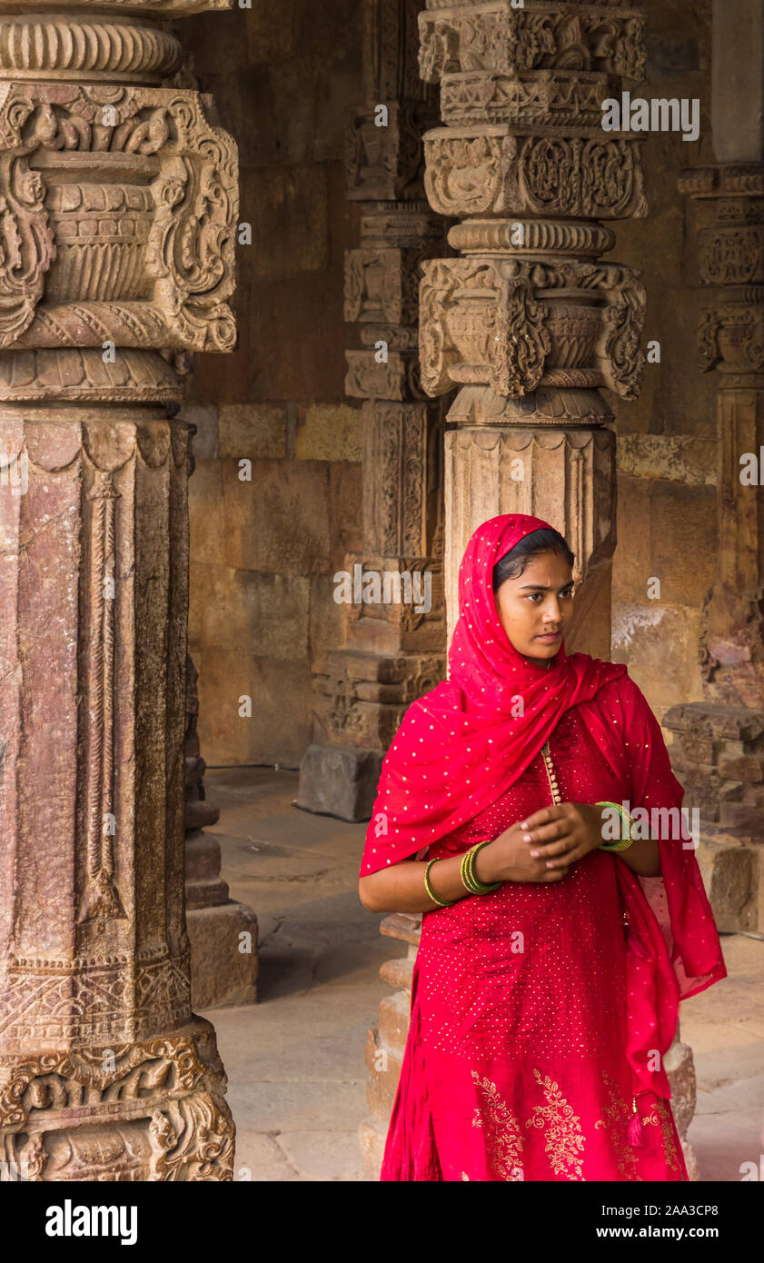 Beautiful young indian woman in red dress at the Qutub Minar in New ...