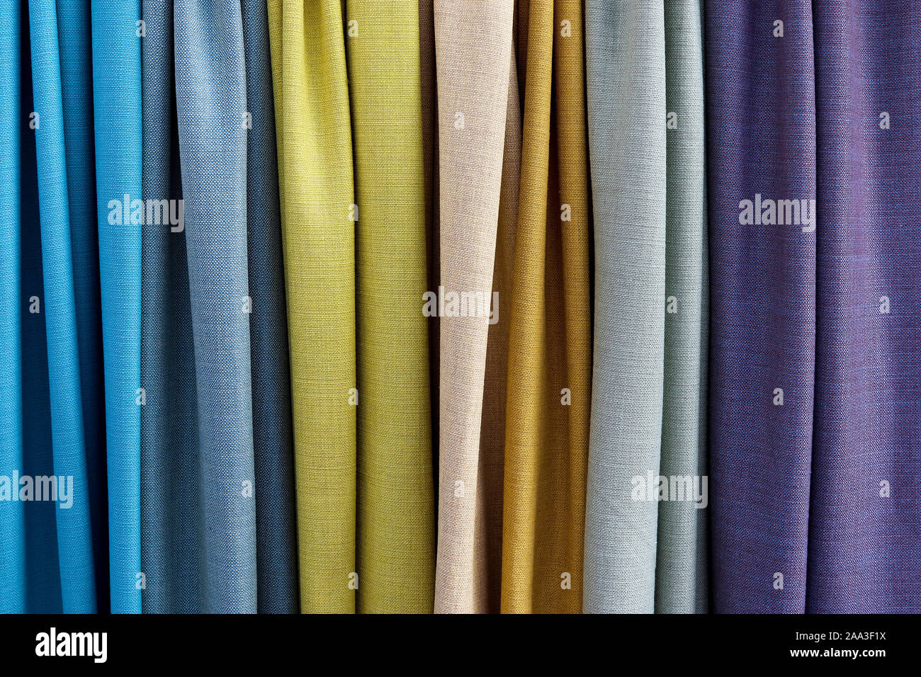 Close up view on folded cloth and fabric textures in different colors ...