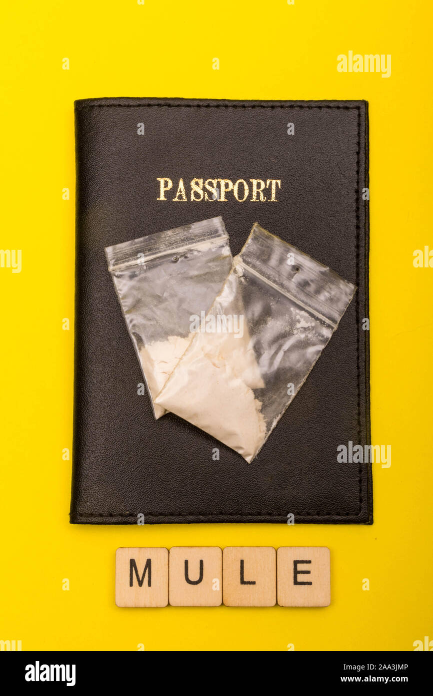 Drug smuggling concept showing a passport on a yellow background with ...
