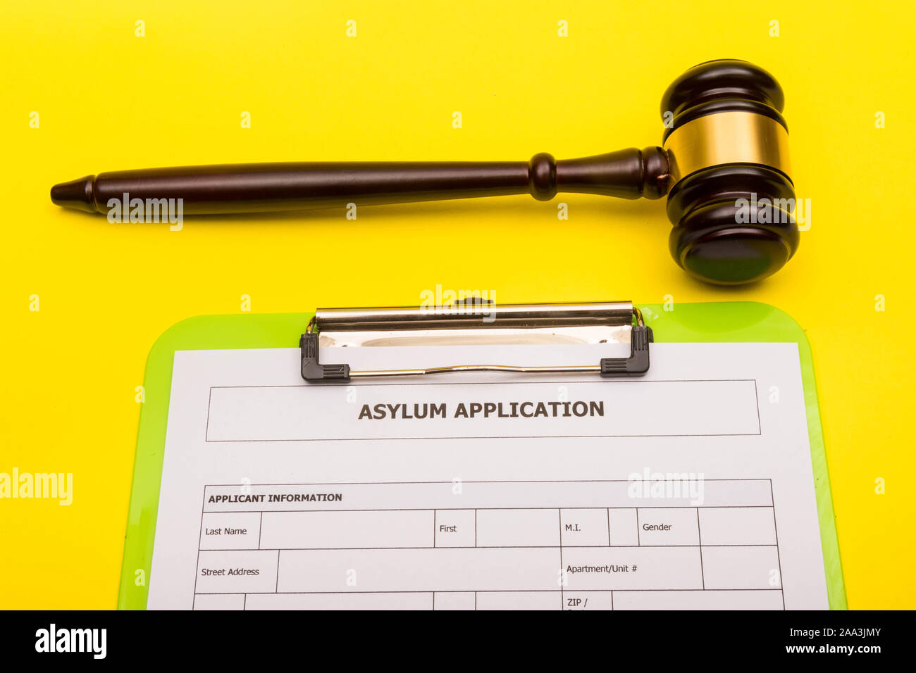 Asylum concept showing an application form for asylum on a yellow ...