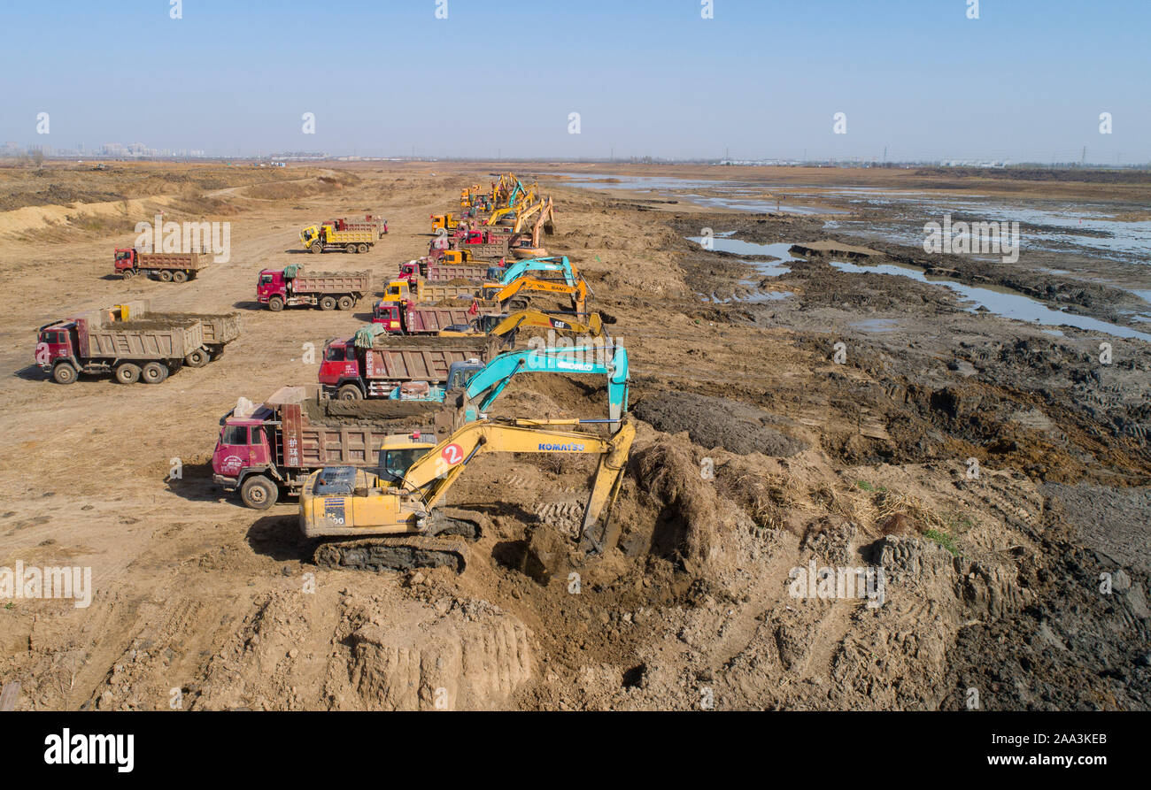 Chinese workers drive bulldozers and other machineries to clear away ...