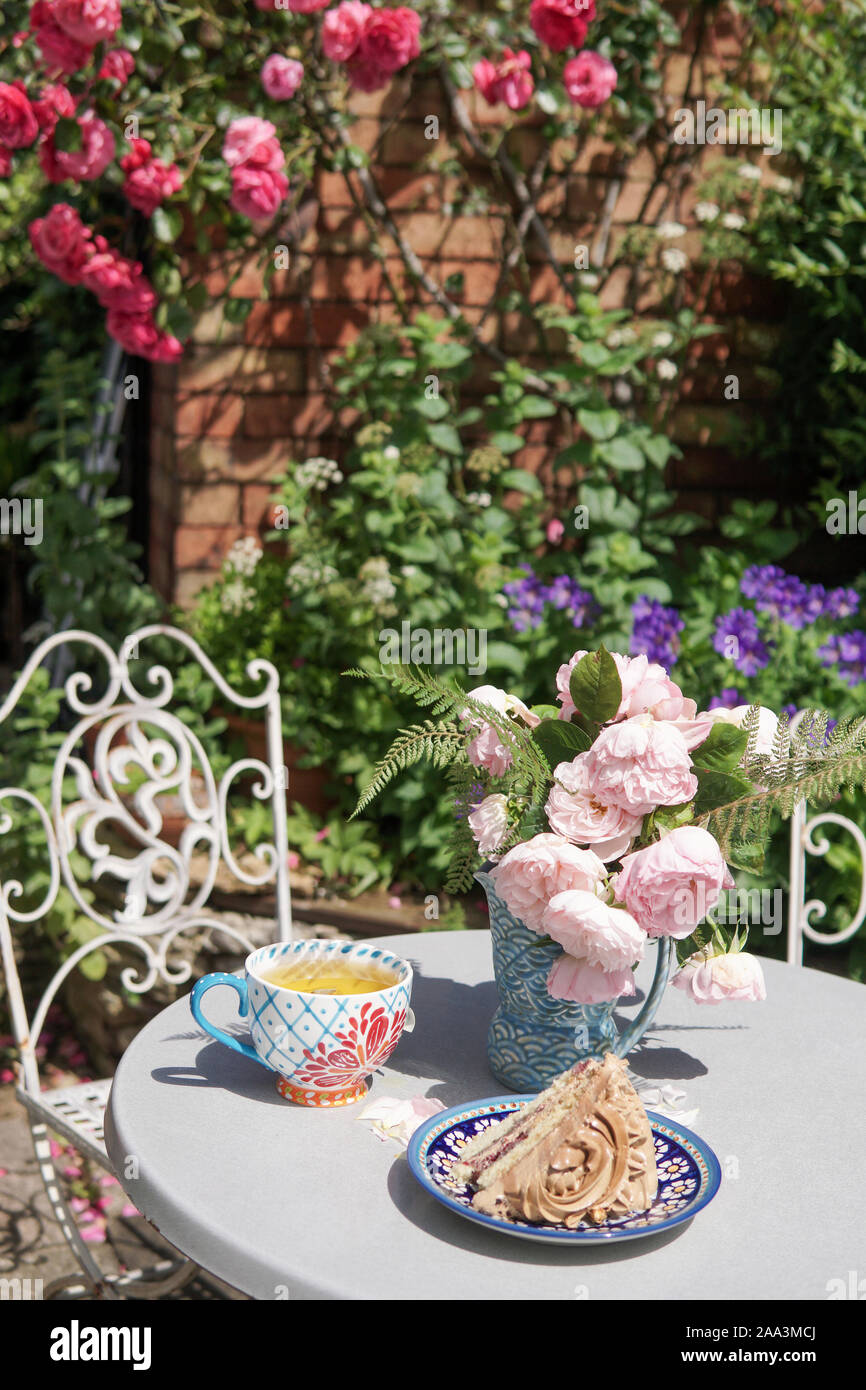 Tea and cake in an English rose garden in the summer, England, United ...