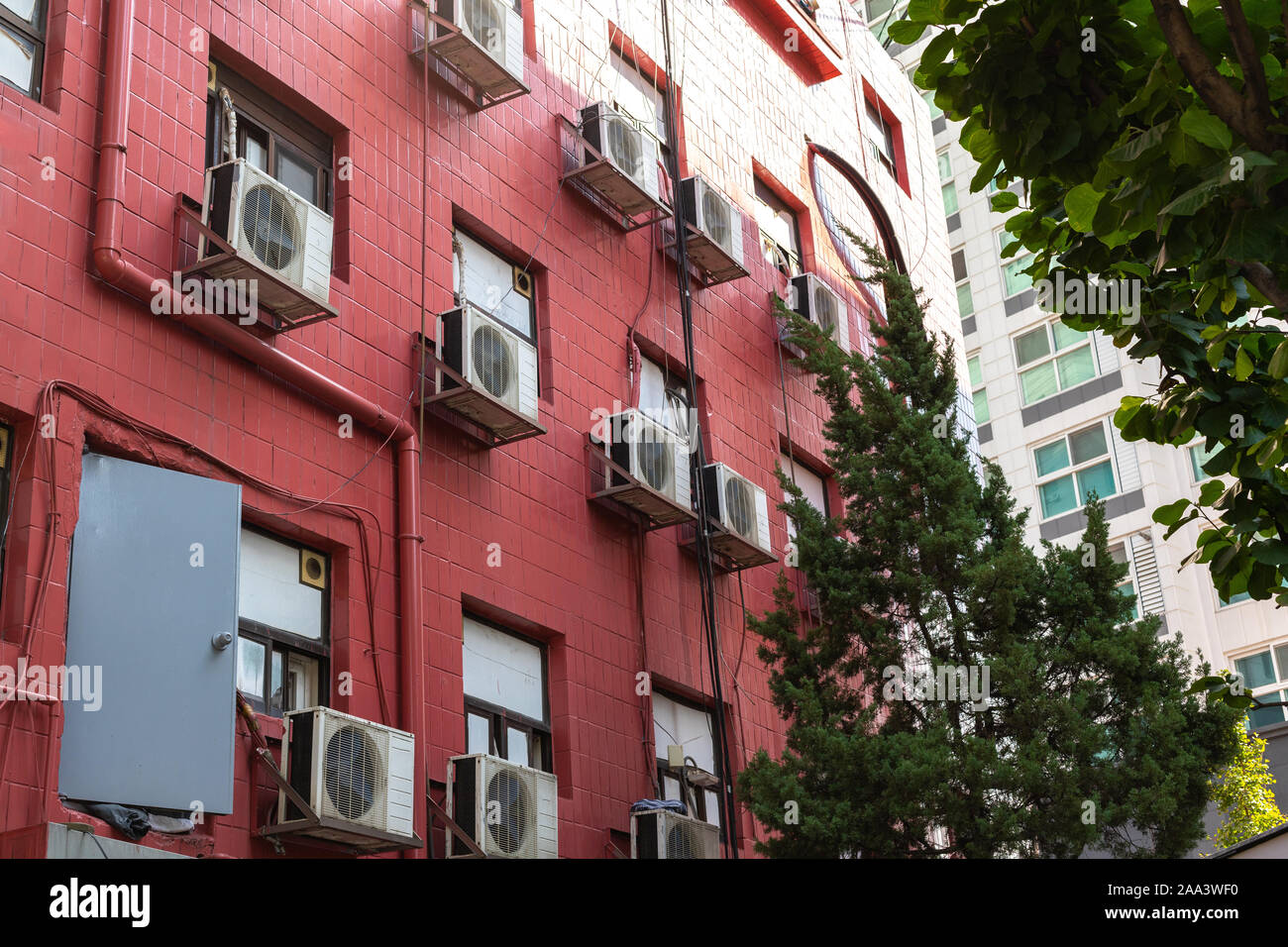 High-rise building from the yard. Facade is made of red tiles, an iron ...