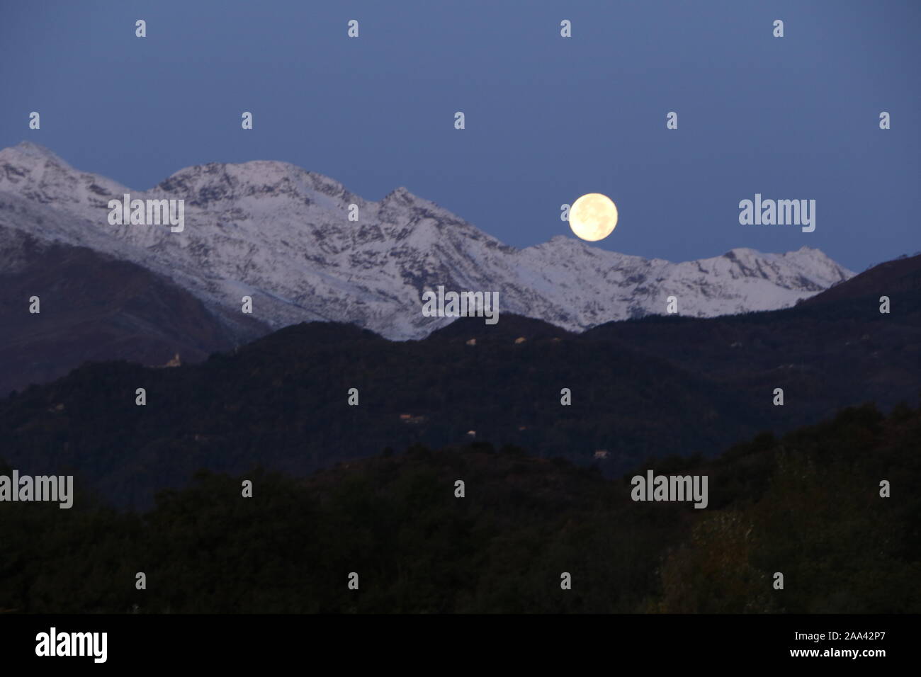 The Moon Setting Behind a mountain Stock Photo - Alamy