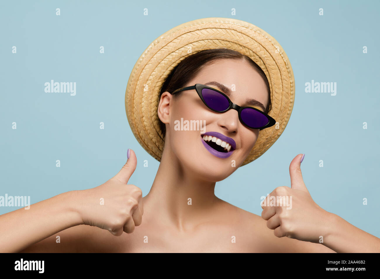 Portrait of beautiful woman with bright make-up, hat and sunglasses on ...