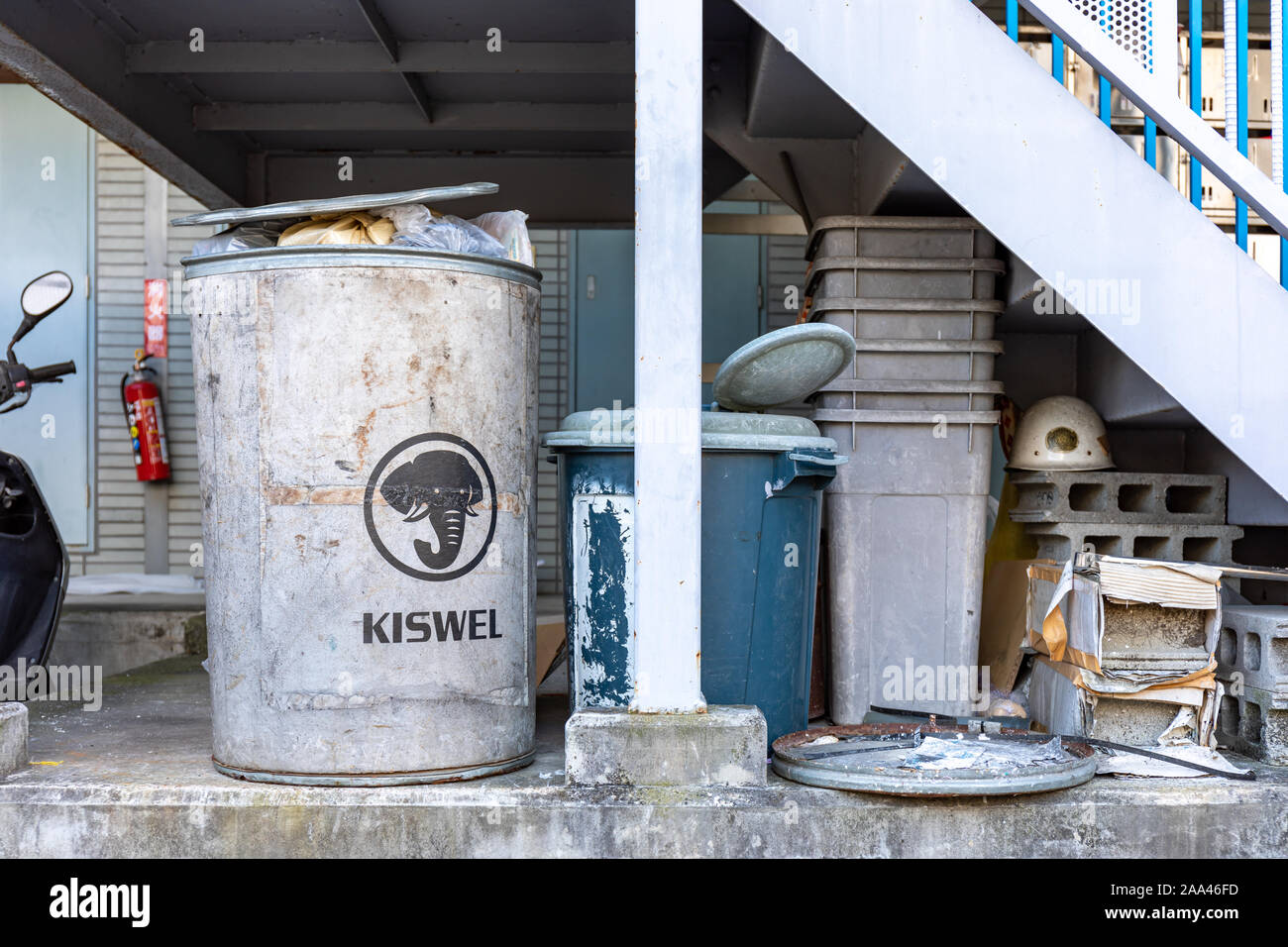 Waste containers under staircase outside apartment building; Japan ...