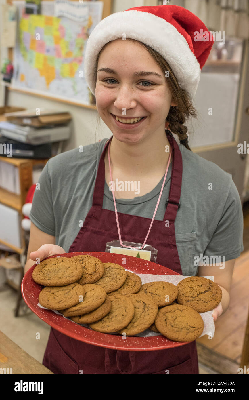 A teenage employee offering cookies to shoppers Stock Photo - Alamy