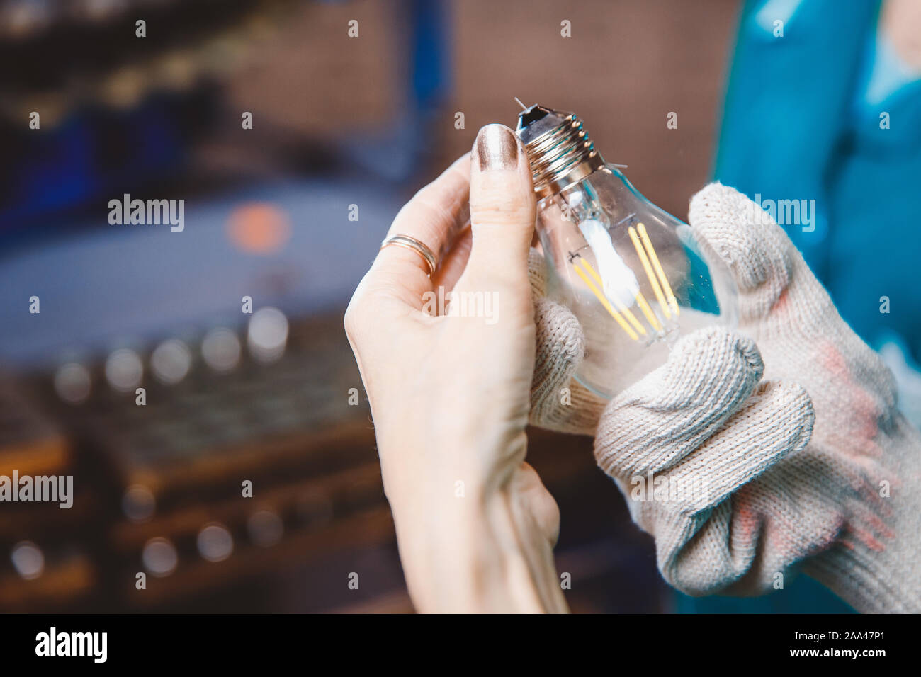 Worker hands picks up electric glass lamp, put cap on wires Stock Photo ...