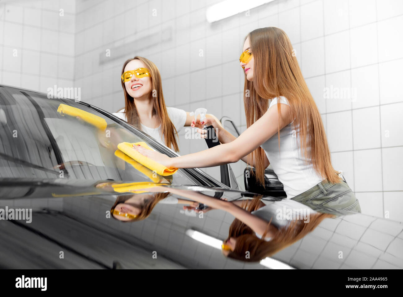 Beautiful women smiling washing car window clean spray Stock Photo - Alamy