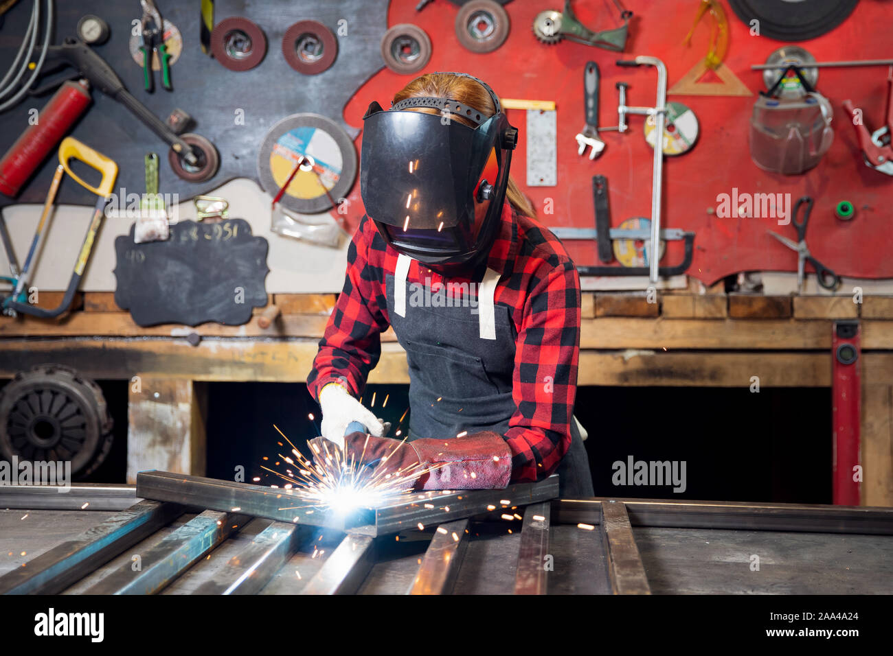 Industrial work, welder works with metal, sparks and fire on background ...
