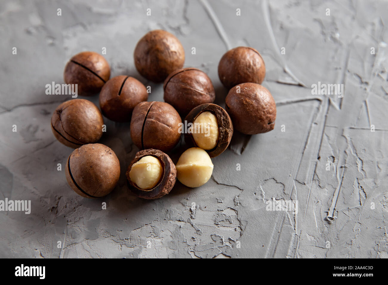 Pile macadamia nuts open kernels and shells on gray concrete background ...