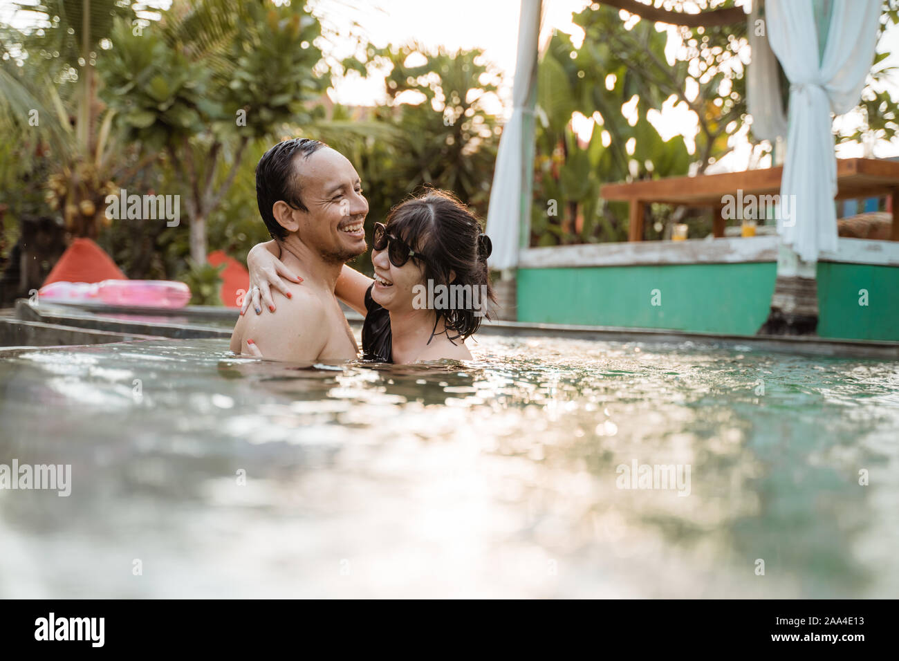 Happy couple hugging in a swimming pool Stock Photo - Alamy