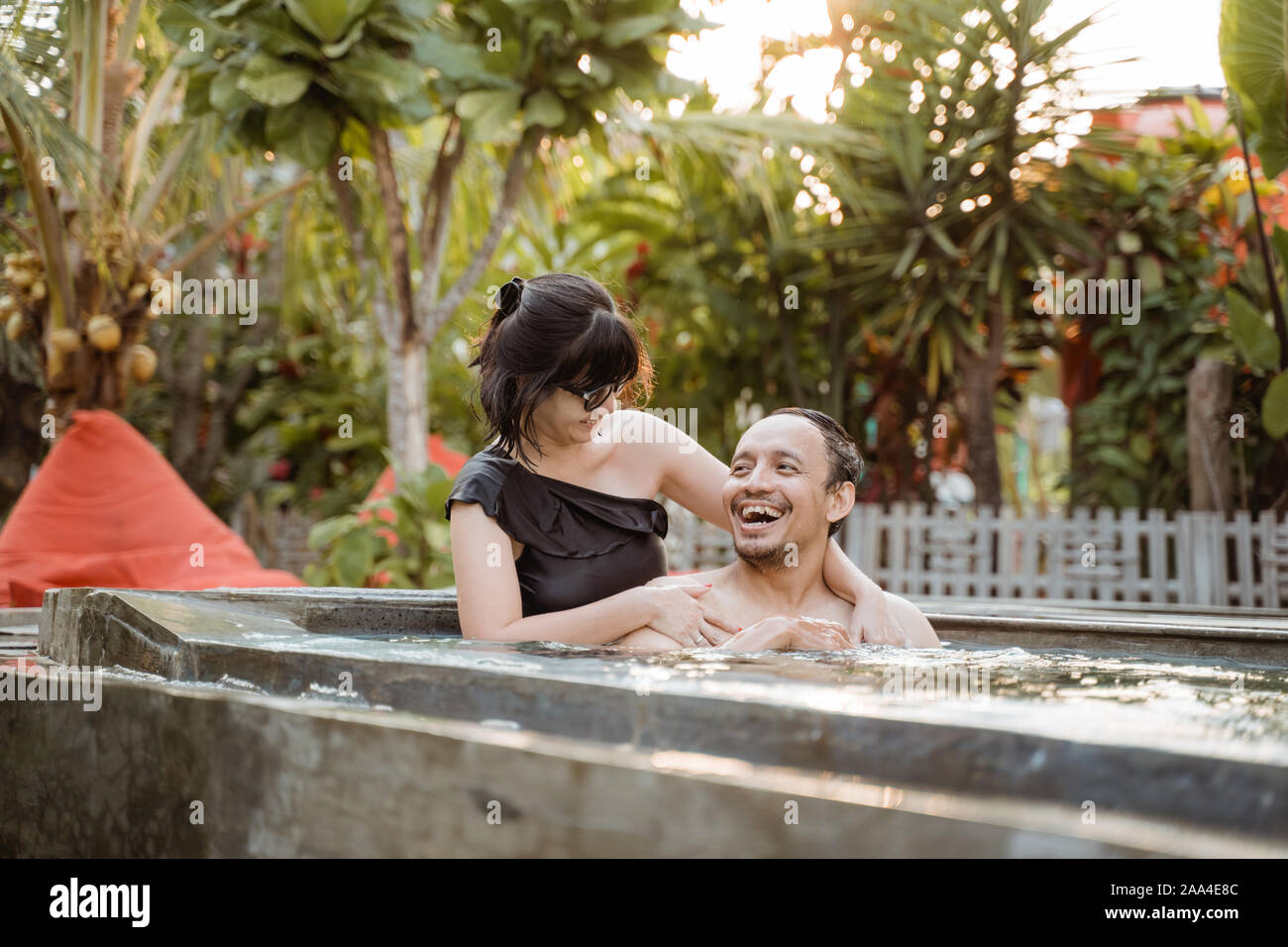 Happy couple hugging in a swimming pool Stock Photo - Alamy