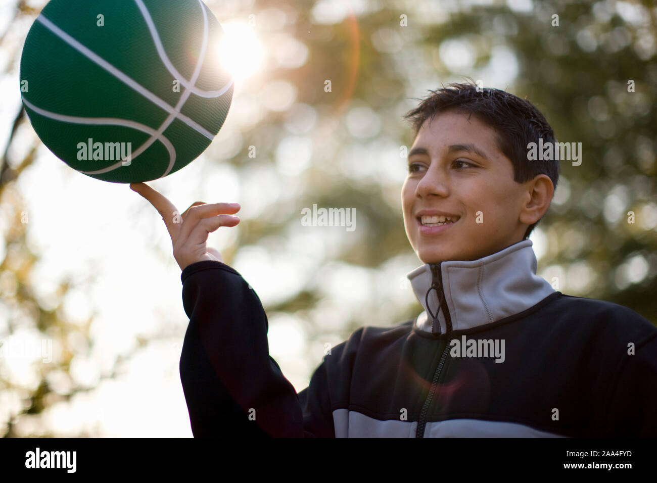 Teenage boy spinning basketball on one finger Stock Photo - Alamy