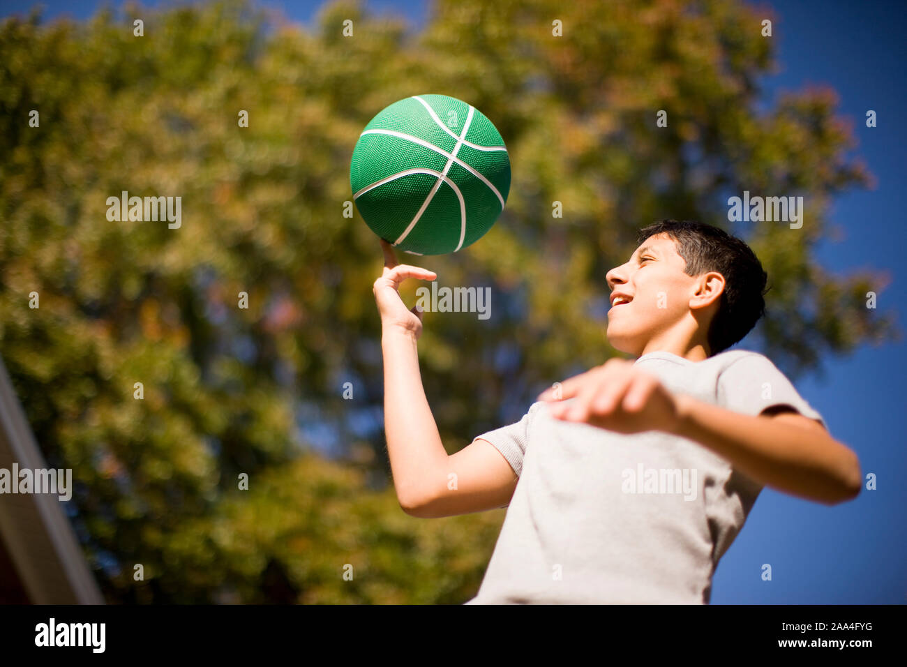 Teenage boy spinning basketball on one finger Stock Photo - Alamy