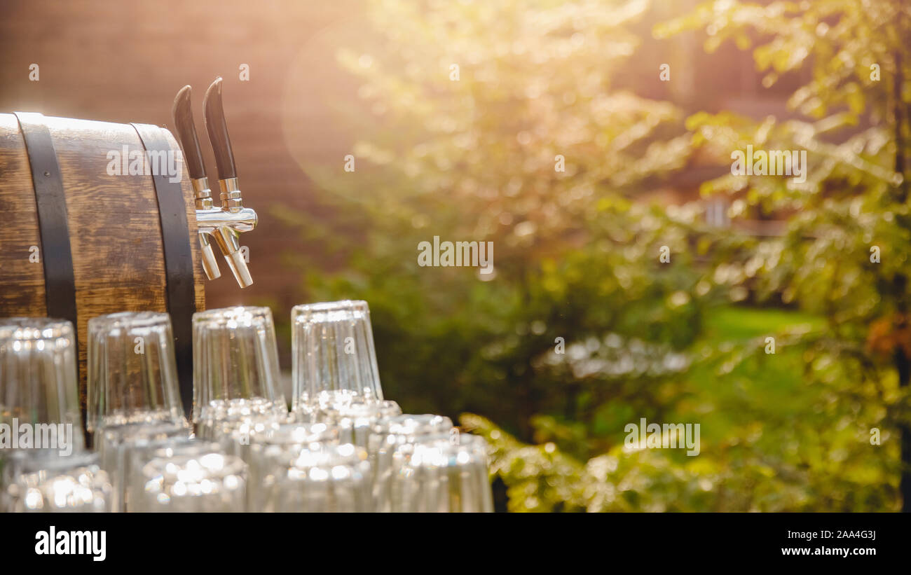 Wooden keg with taps for beer pouring drink into mugs bar, summer ...