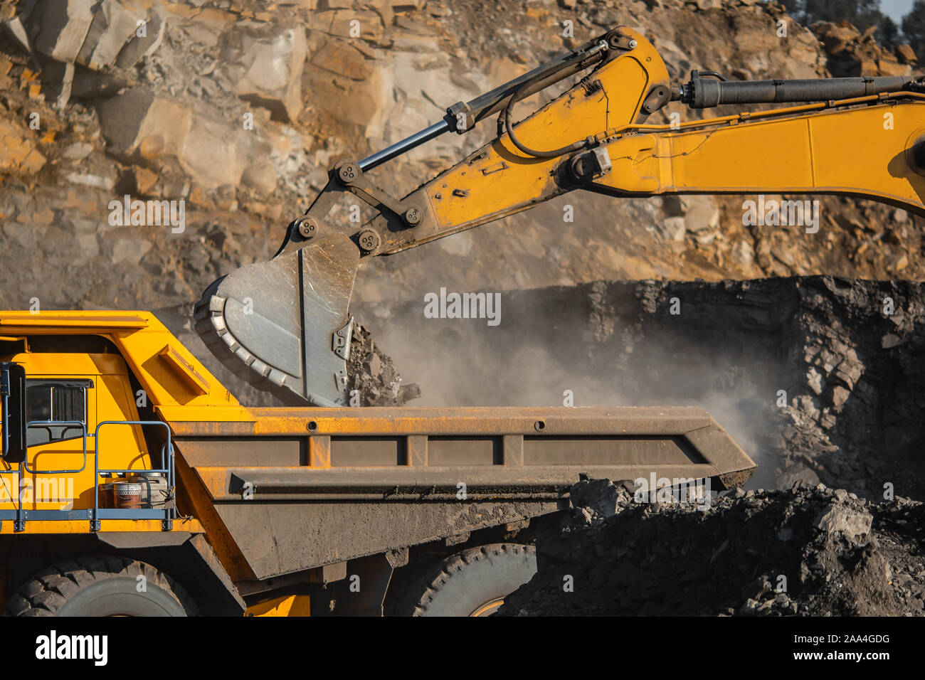 Open pit mine industry, excavator loading coal on big yellow mining ...