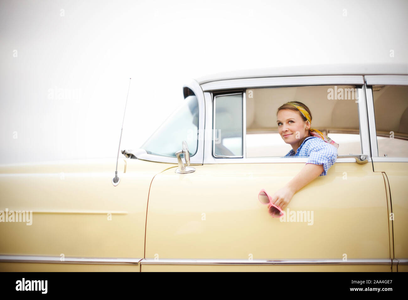 Young woman in 1950s outfit driving a vintage car Stock Photo - Alamy