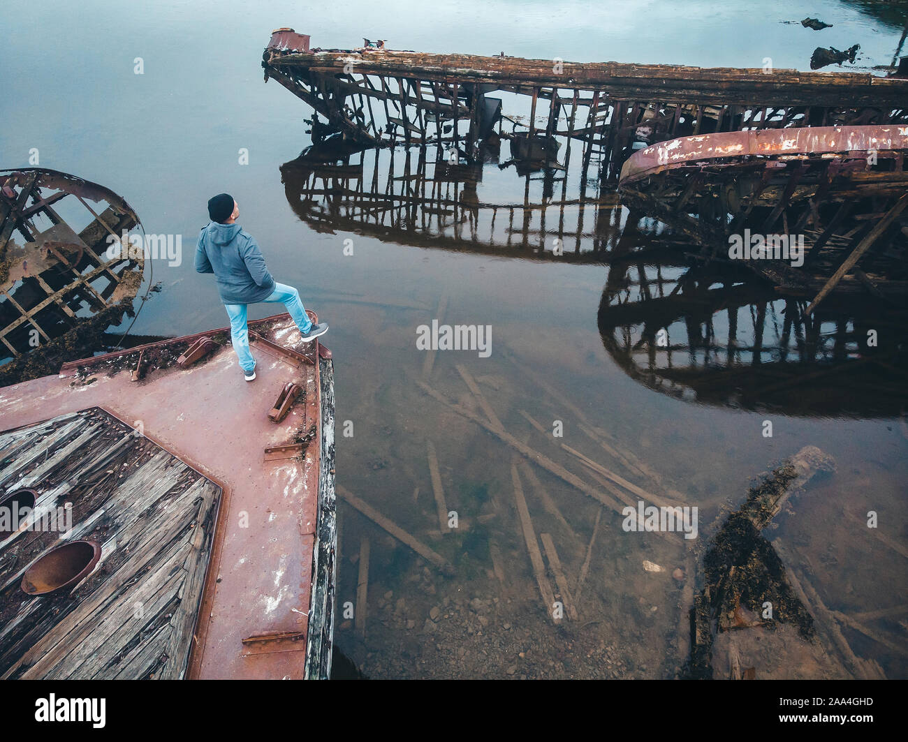 Tourist man looks at the cemetery of old wooden ships Teriberka ...