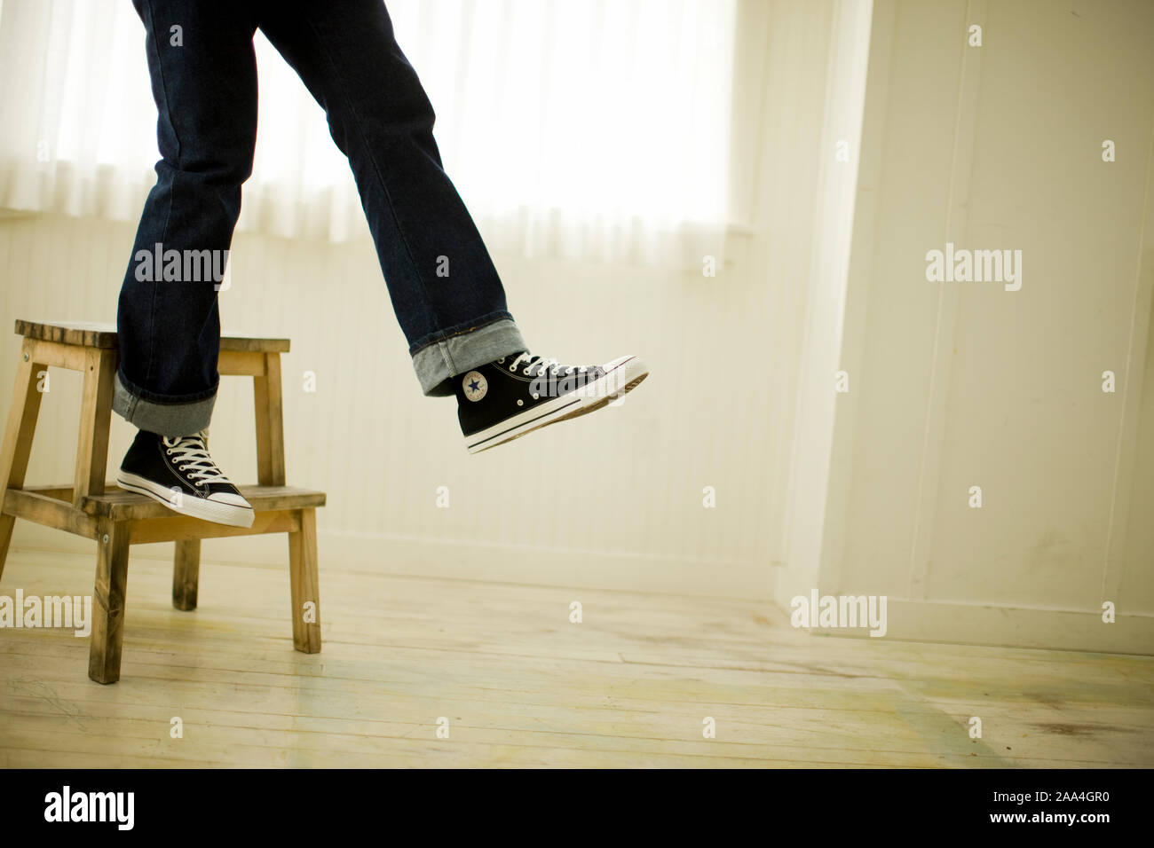 Young man's legs on a step ladder Stock Photo - Alamy
