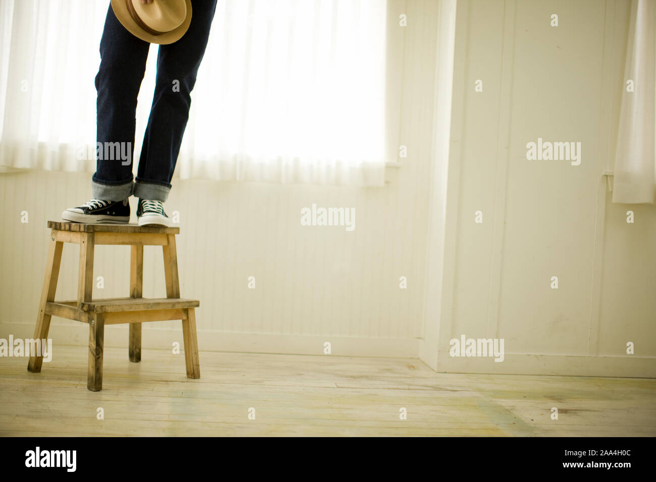 Young man's legs on a step ladder Stock Photo - Alamy