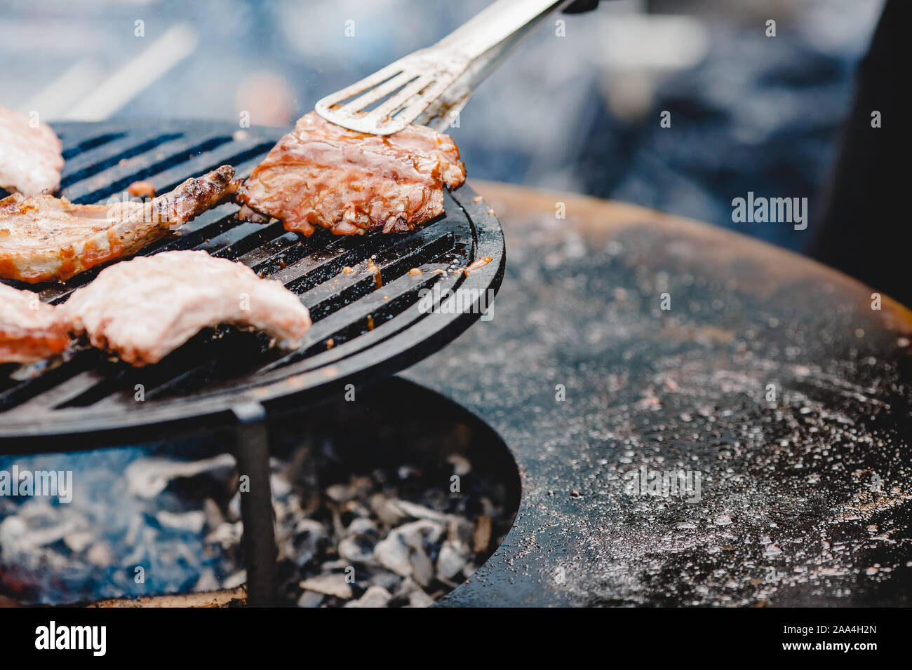 Pork ribs and steak cooked on grill, open fire street food festival ...