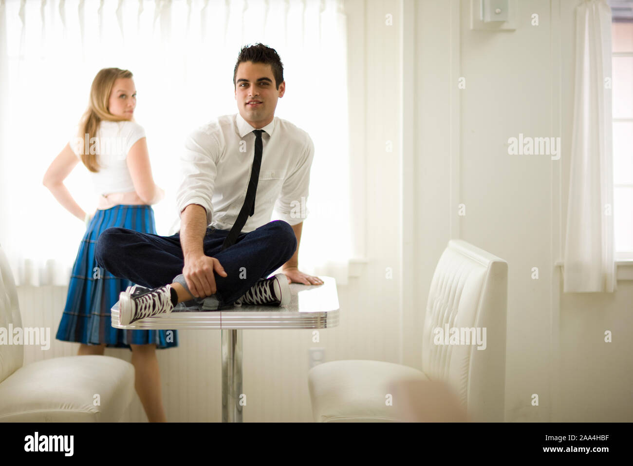 Man sitting on top of table Stock Photo - Alamy