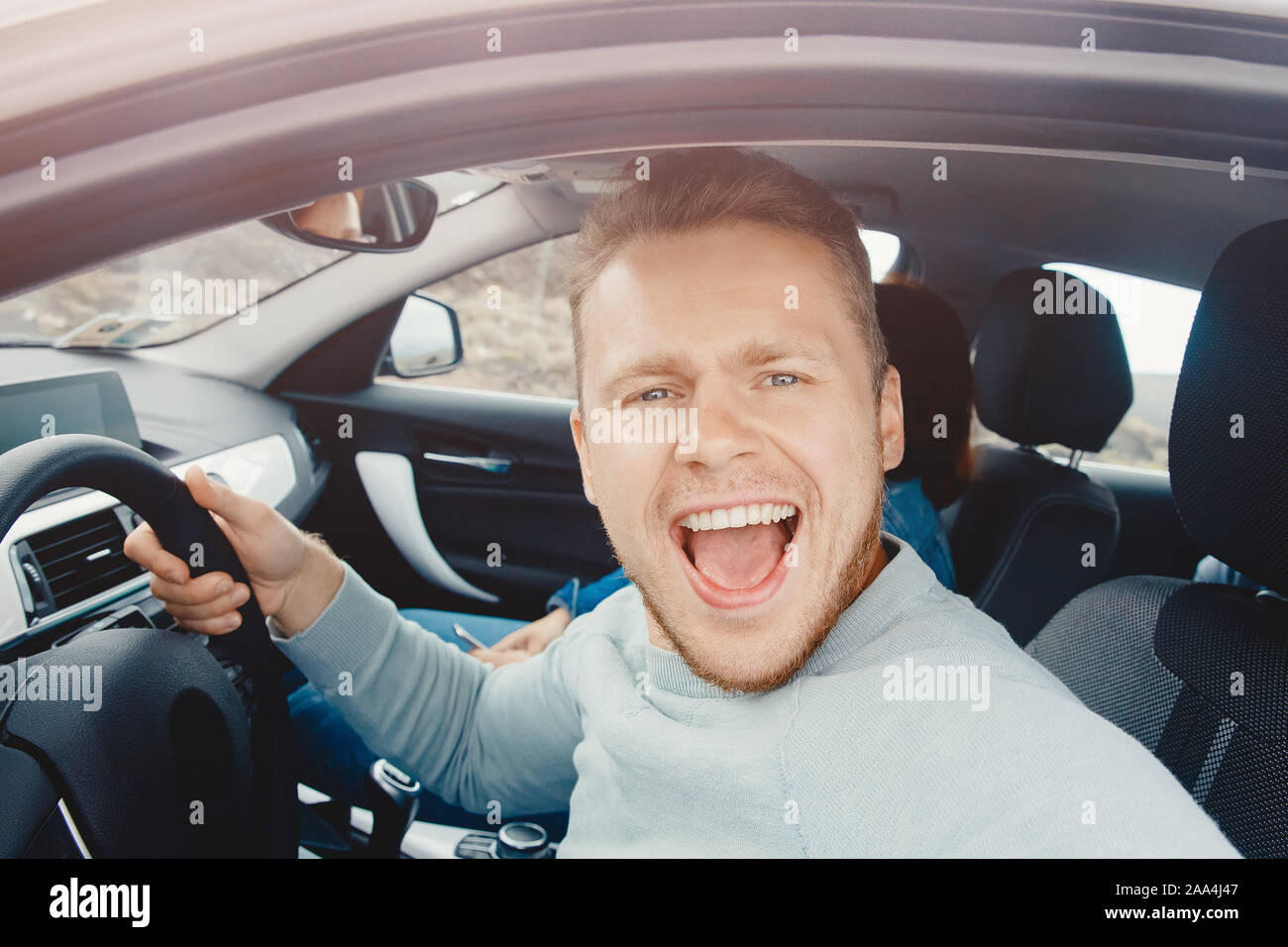 Male driver smiles and takes selfie photo. Car travel rental concept ...