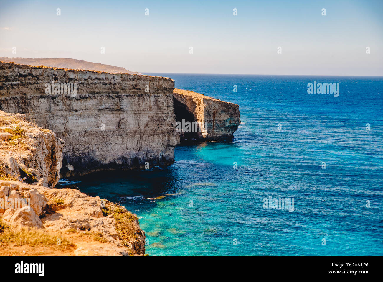 Blue emerald sea water with large stones beach. Rocky shore transparent ...