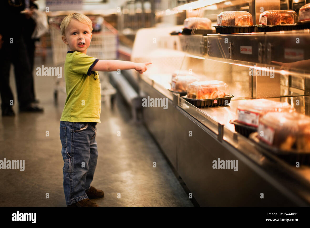 Little boy pointing to food in a supermarket warmer Stock Photo - Alamy