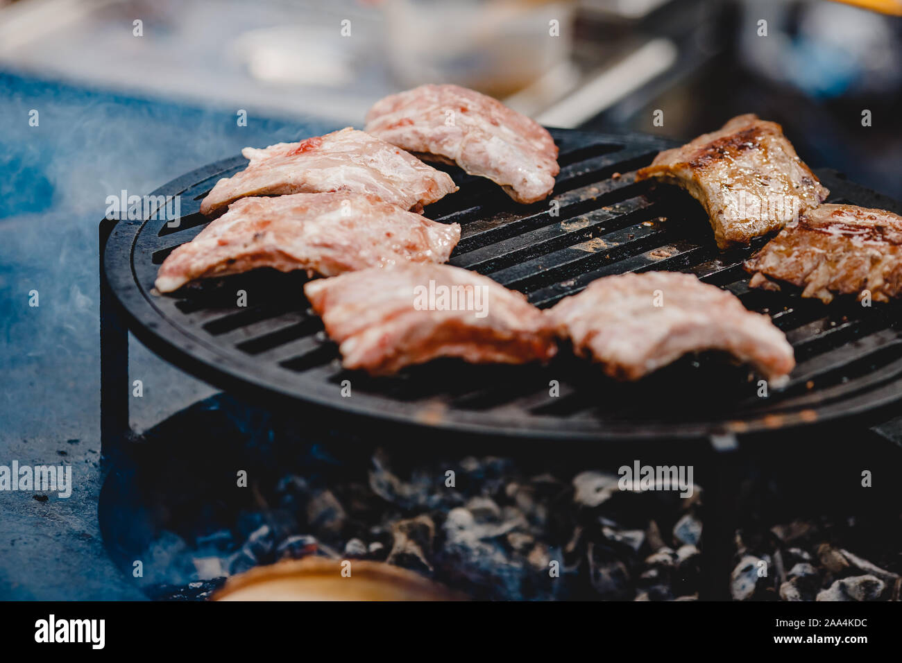 Pork ribs and steak cooked on grill, open fire street food festival ...