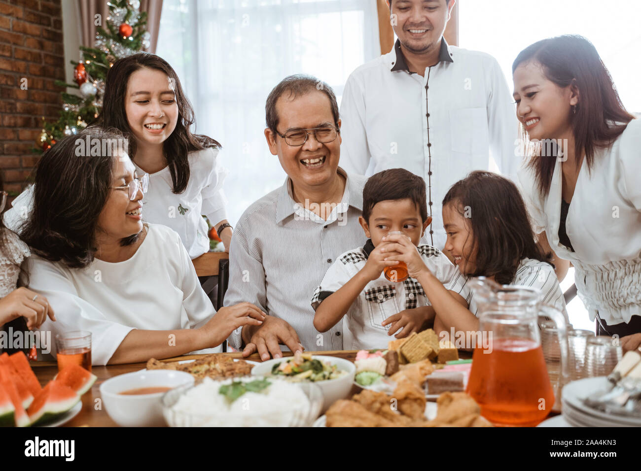 family fun having lunch with friends in diningroom together Stock Photo ...