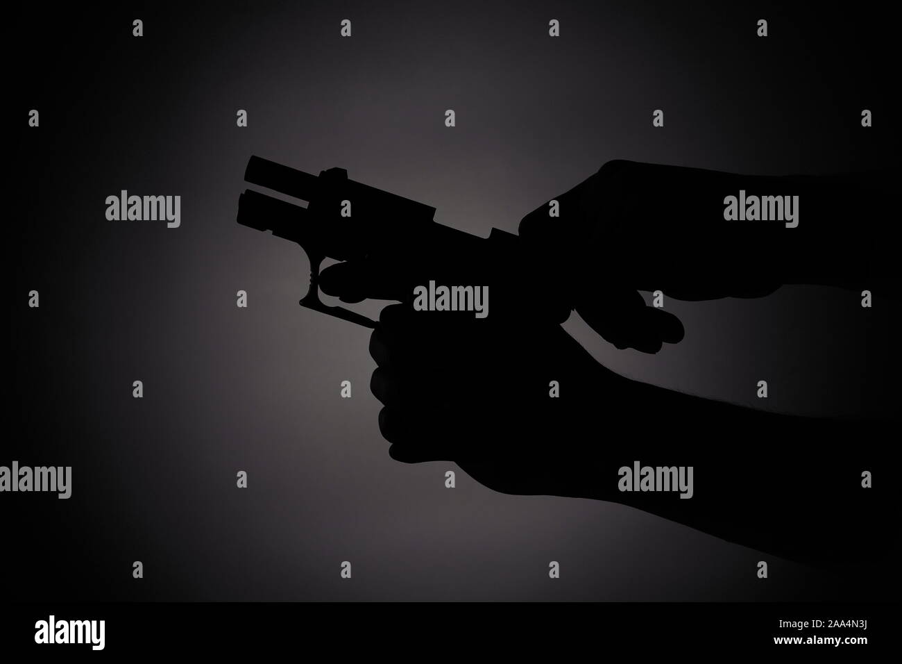 attacking with a gun, reloading -shadow in the dark Stock Photo - Alamy