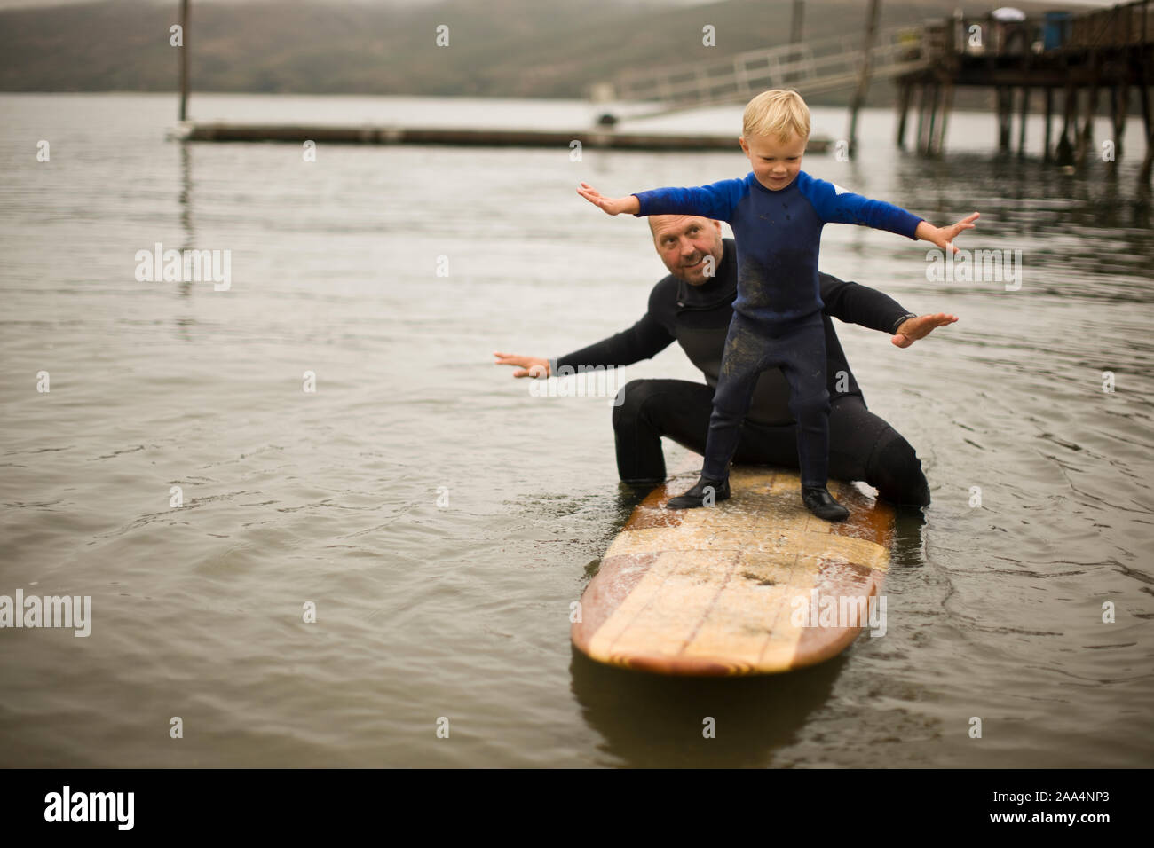 Father and son playing on surfboard Stock Photo - Alamy