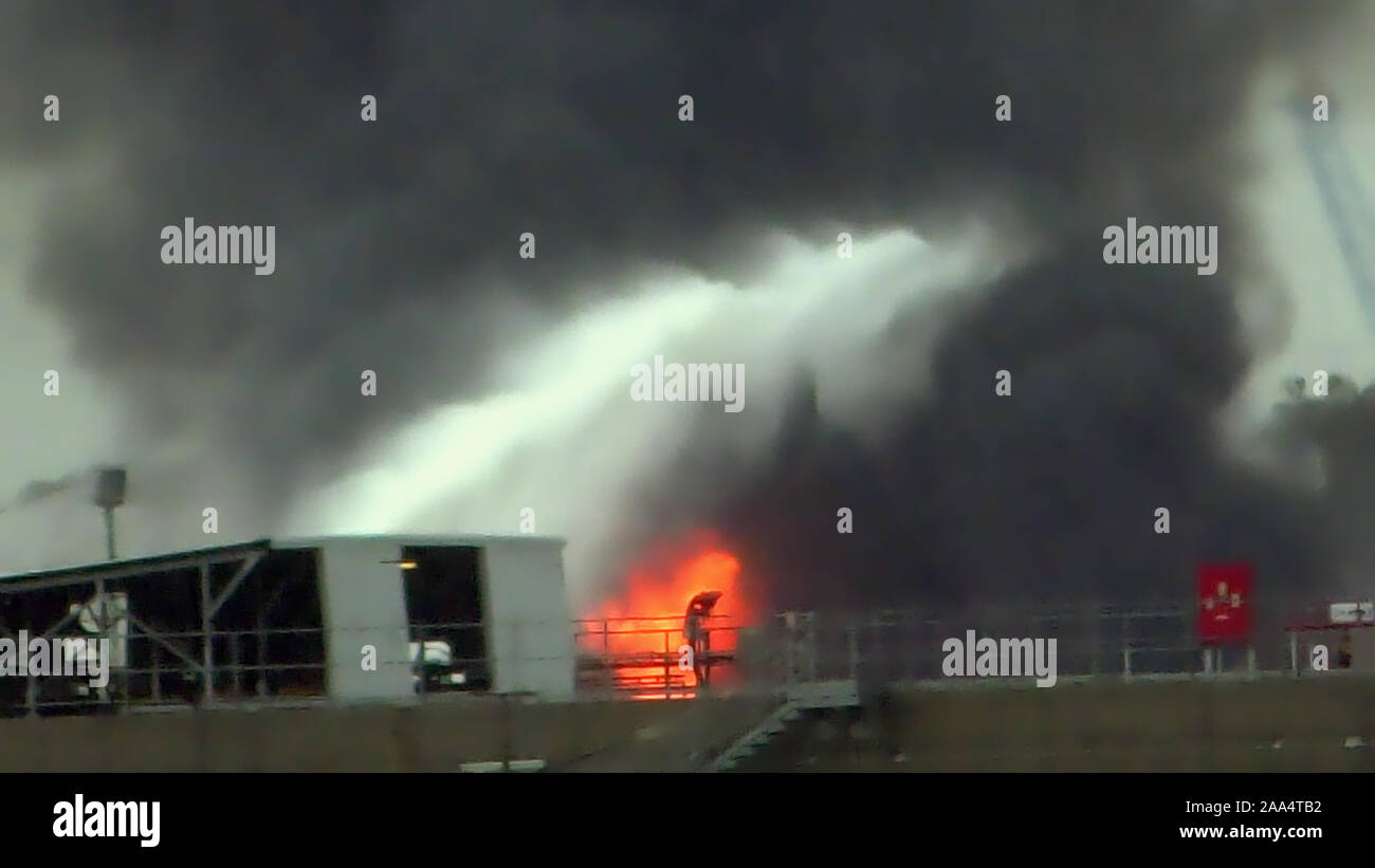 Firefighter water jet extinguish the fire started near a petrol storage ...