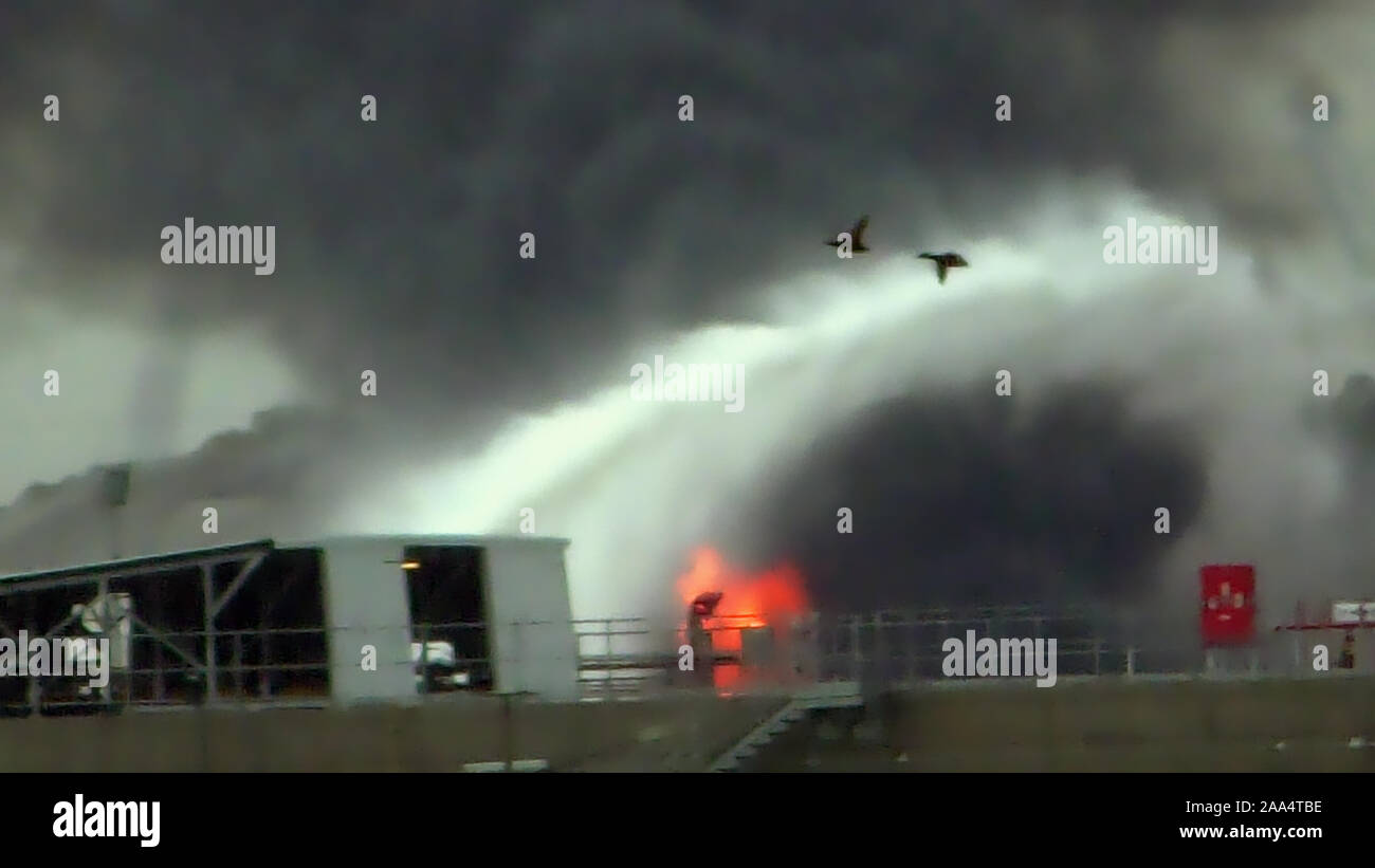 Firefighter water jet extinguish the fire started near a petrol storage ...