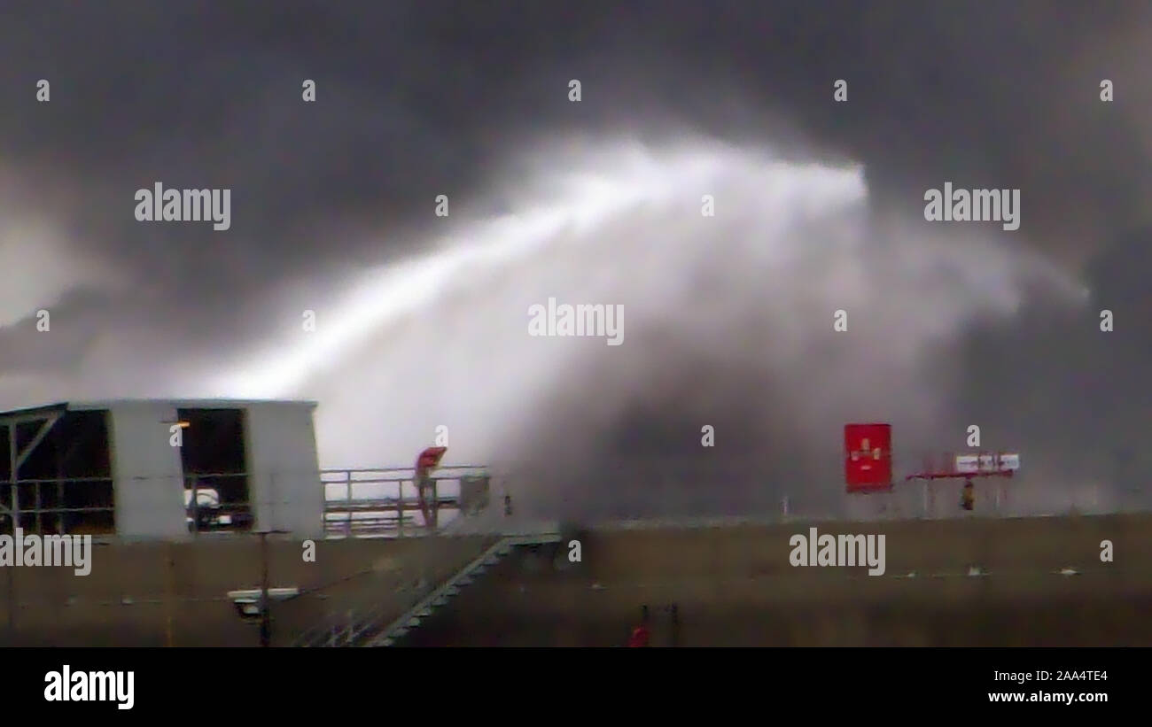 Firefighter water jet extinguish the fire started near a petrol storage ...