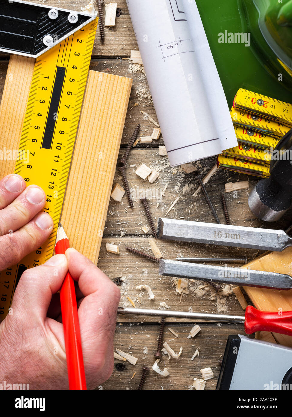 Top view. Carpenter with pencil and the carpenter's square draw the ...