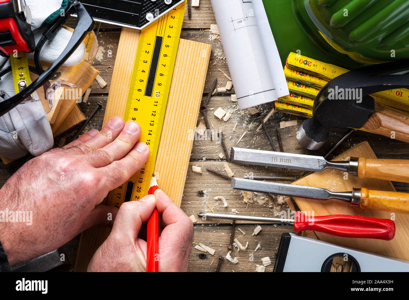 Top view. Carpenter with pencil and the carpenter's square draw the ...