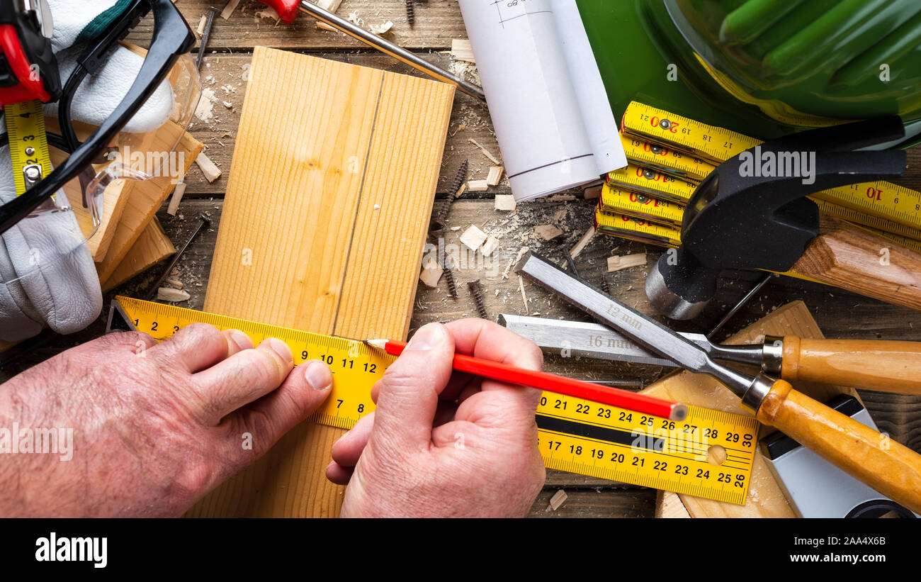 Top view. Carpenter with pencil and the carpenter's square draw the ...