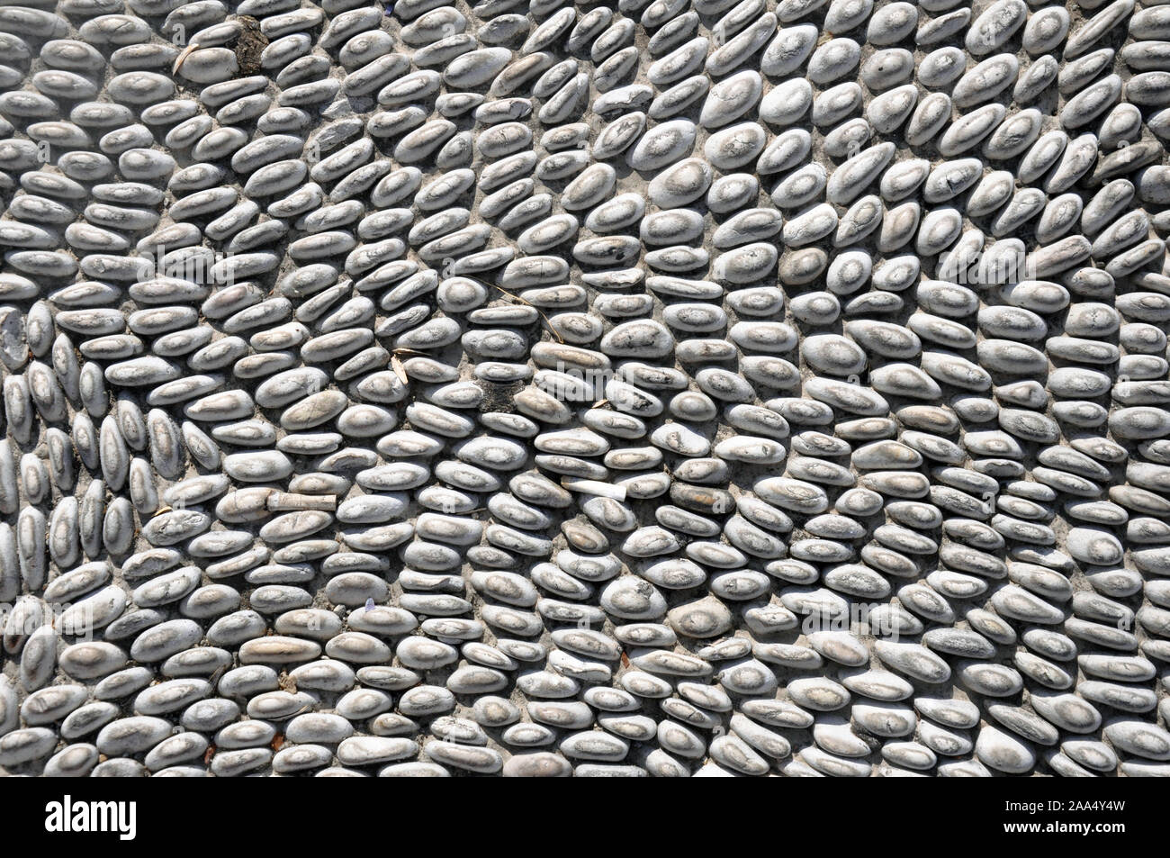 The sidewalk or wall of small pebbles lined with a pattern. Art ...
