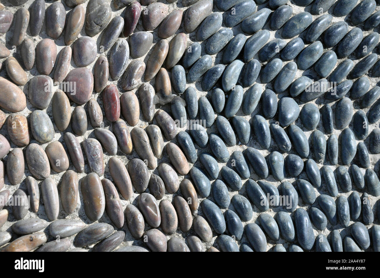 The sidewalk or wall of small pebbles lined with a pattern. Art ...