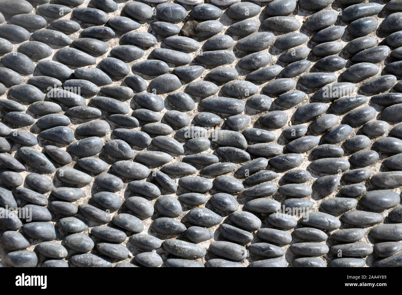 The sidewalk or wall of small pebbles lined with a pattern. Art ...