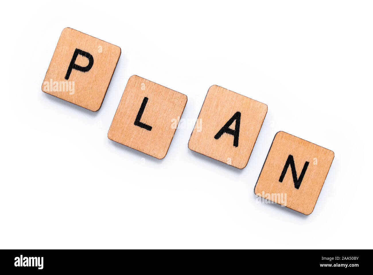 The word PLAN, spelt with wooden letter tiles over a white background ...