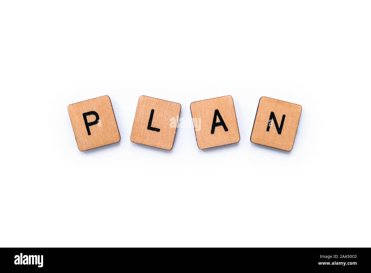 The word PLAN, spelt with wooden letter tiles over a white background ...